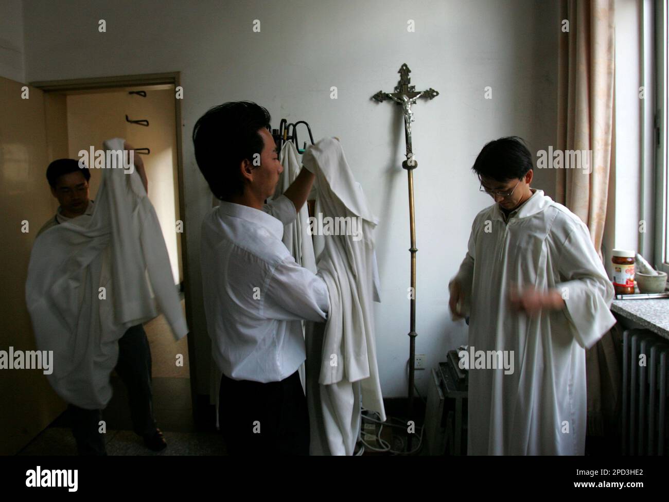 Chinese seminary students put on their robes before mass at a chapel in ...