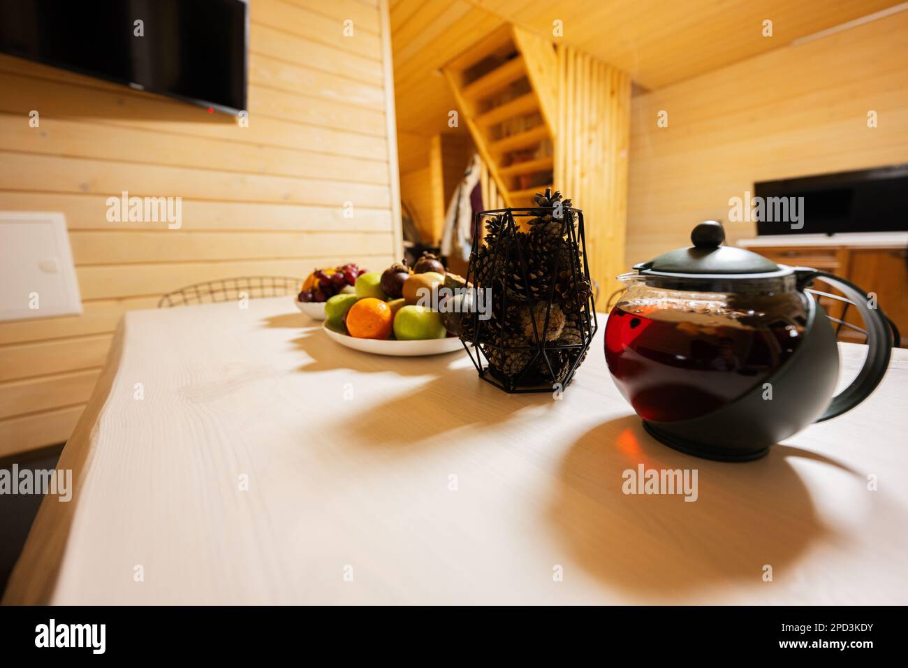 Fruit tea in a teapot in cozy wooden cabin house. Cons at vase. Life in ...
