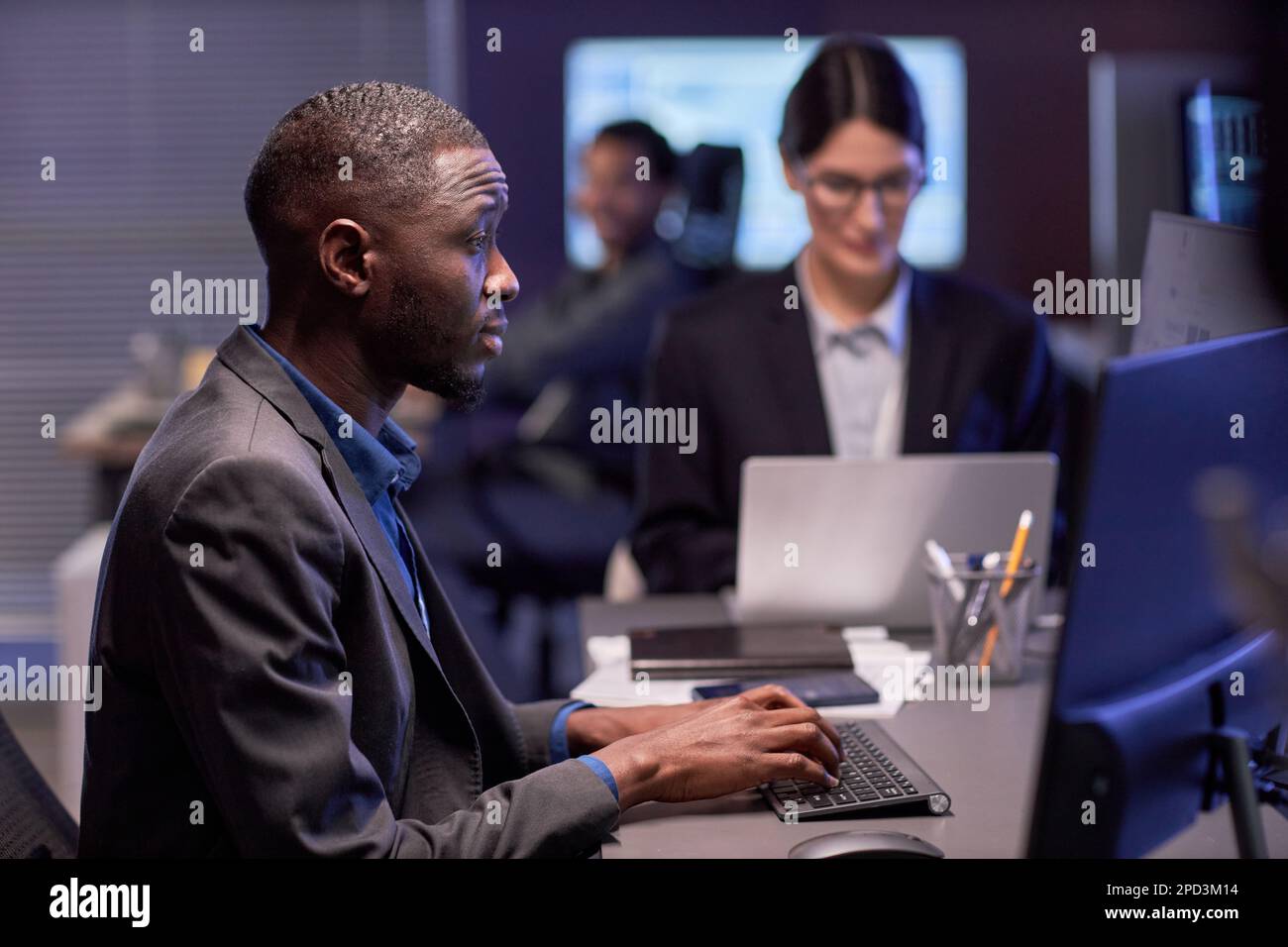 Side view portrait of serious black businessman using laptop at ...