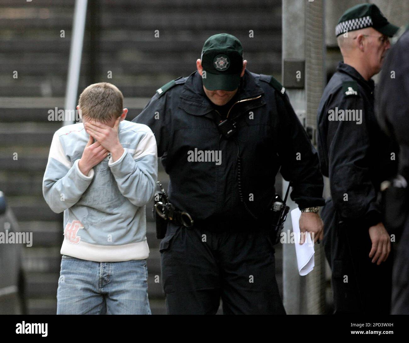 One of the five people charged with murder is led away by police from ...