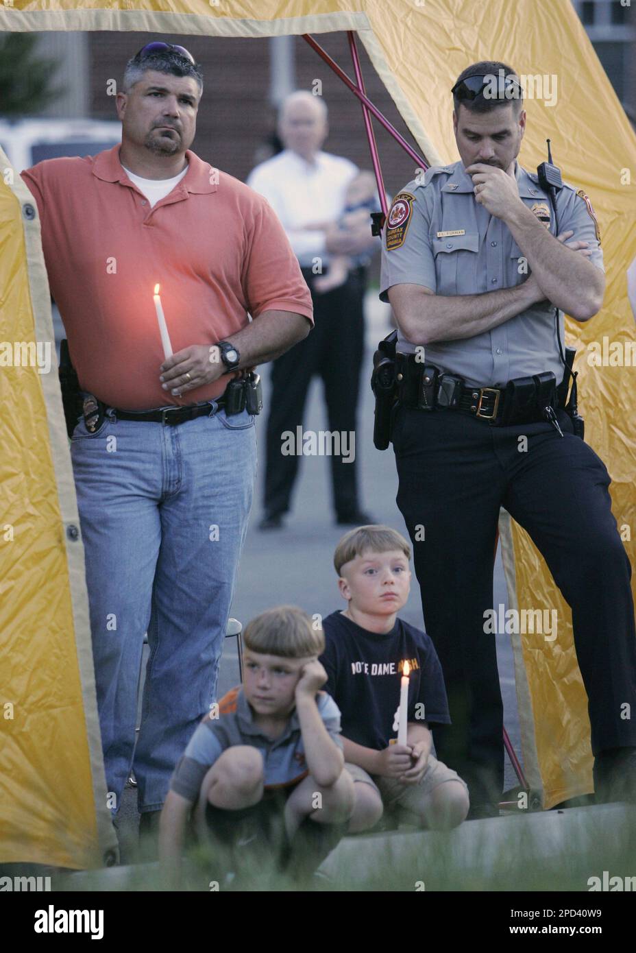 Unidentified Fairfax county police officers stand at a candlelight ...