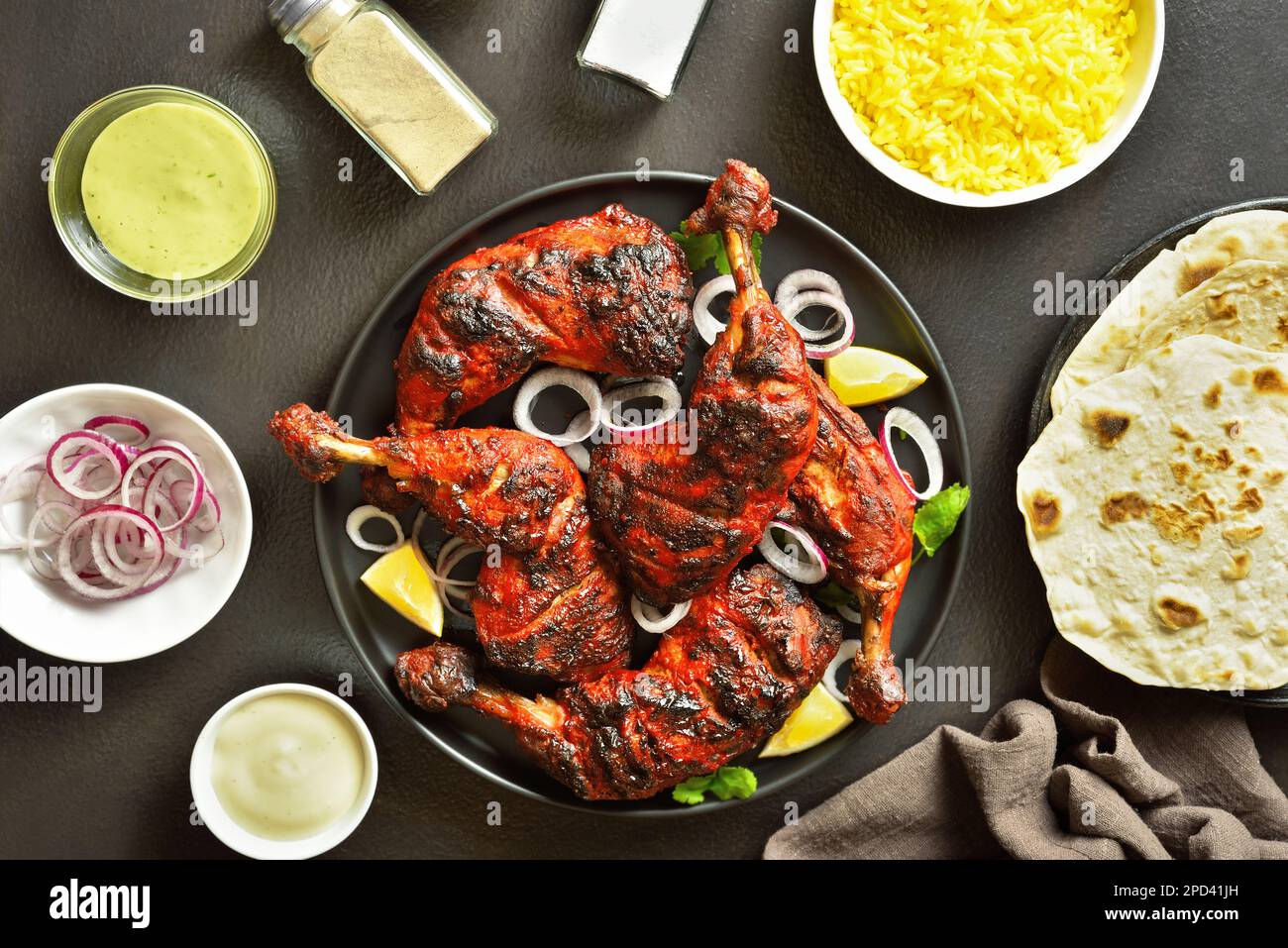 Indian style tandoori chicken on plate over dark stone background ...