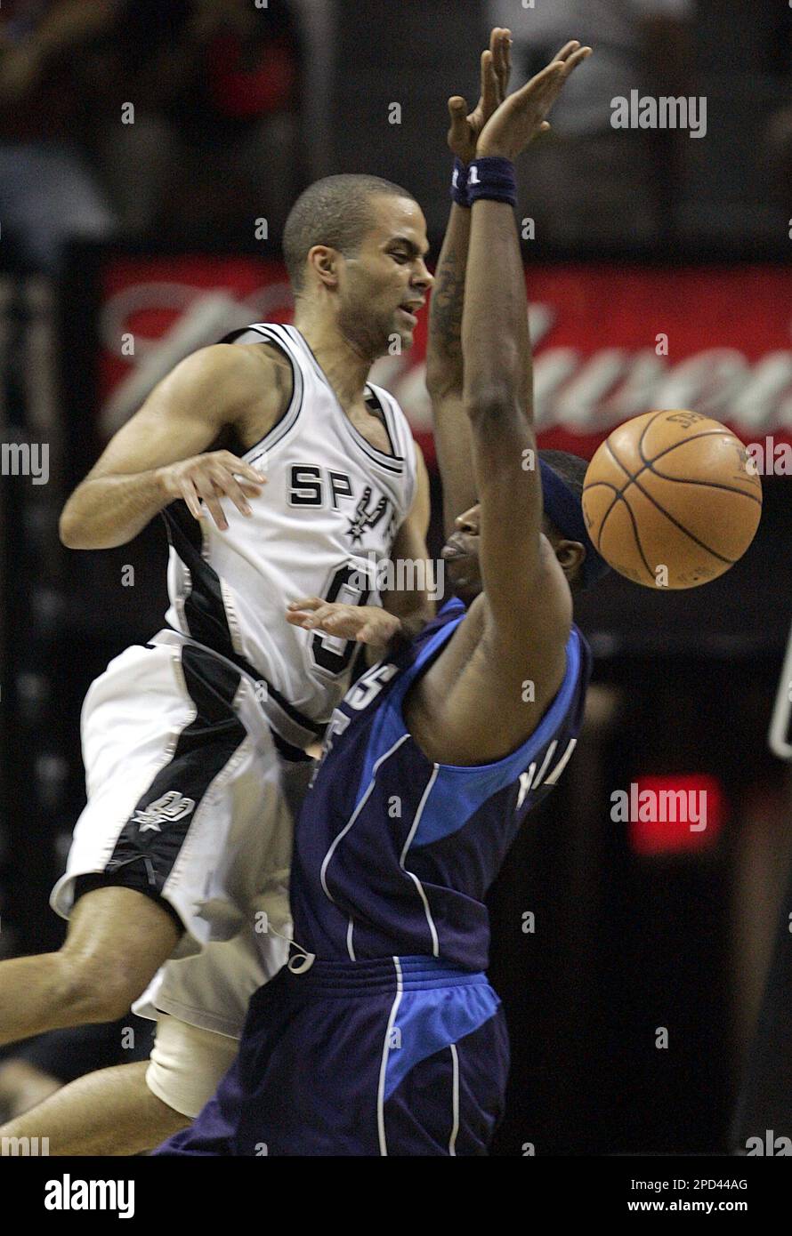 San Antonio Spurs' Tony Parker (9) loses the ball as he runs into Dallas Mavericks' Josh Howard ...