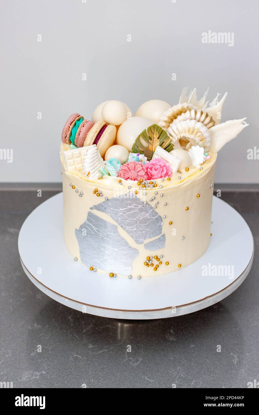 Modern elegant white cake with white chocolate, waffle paper, macaroons ...