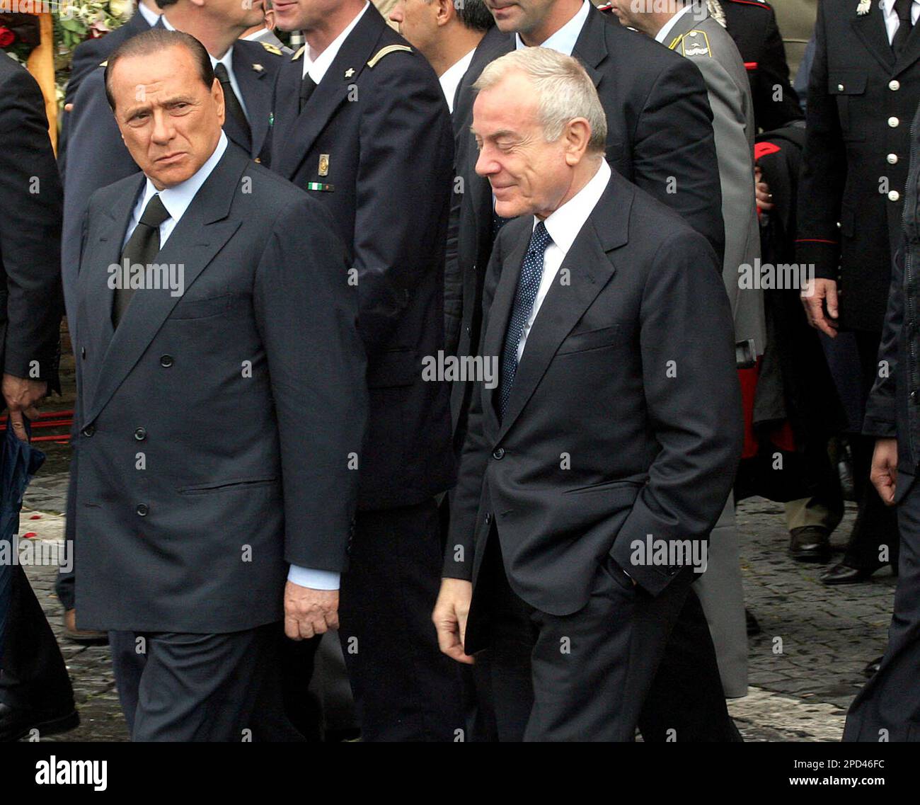 Outgoing Premier Silvio Berlusconi, left, walks with his closest aide ...