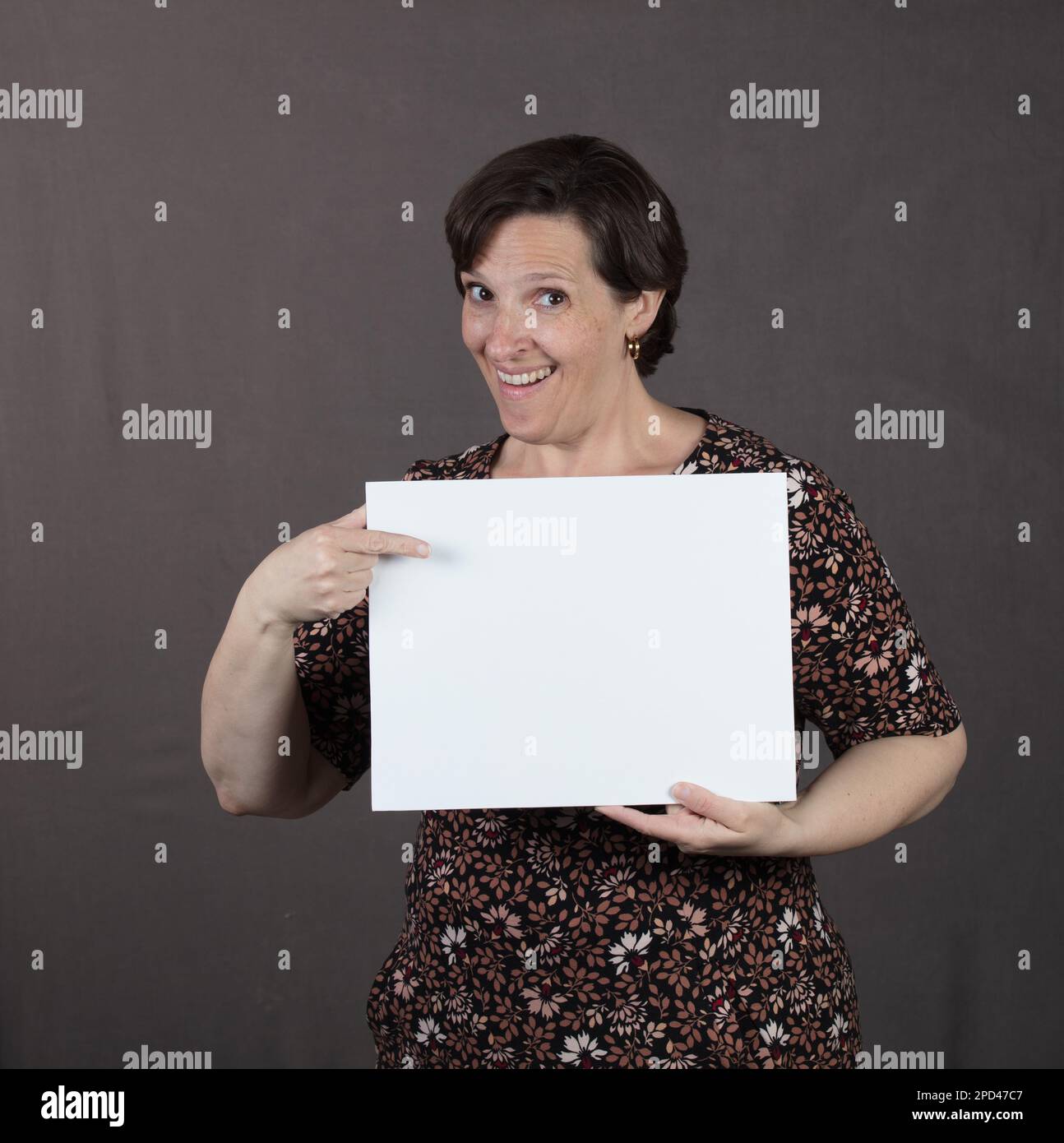 Woman in a print dress holding a white sign Stock Photo - Alamy