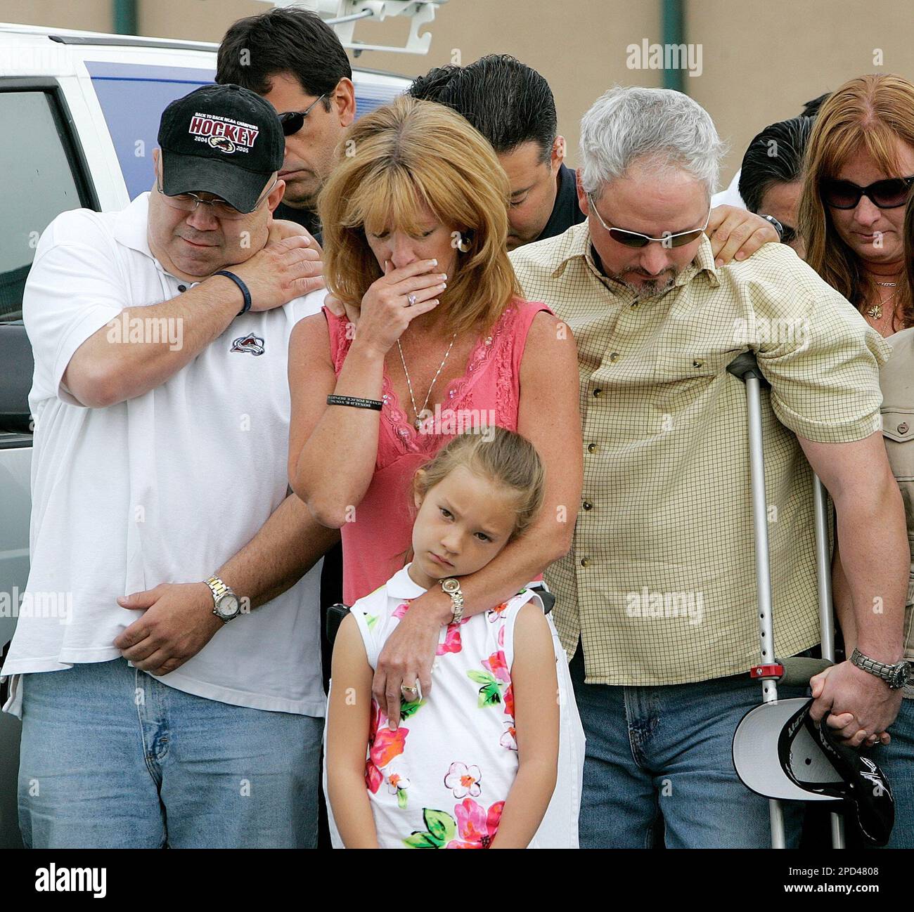 Kelly Young, center, with her daughter Kelsey, 6, wipes away tears as ...
