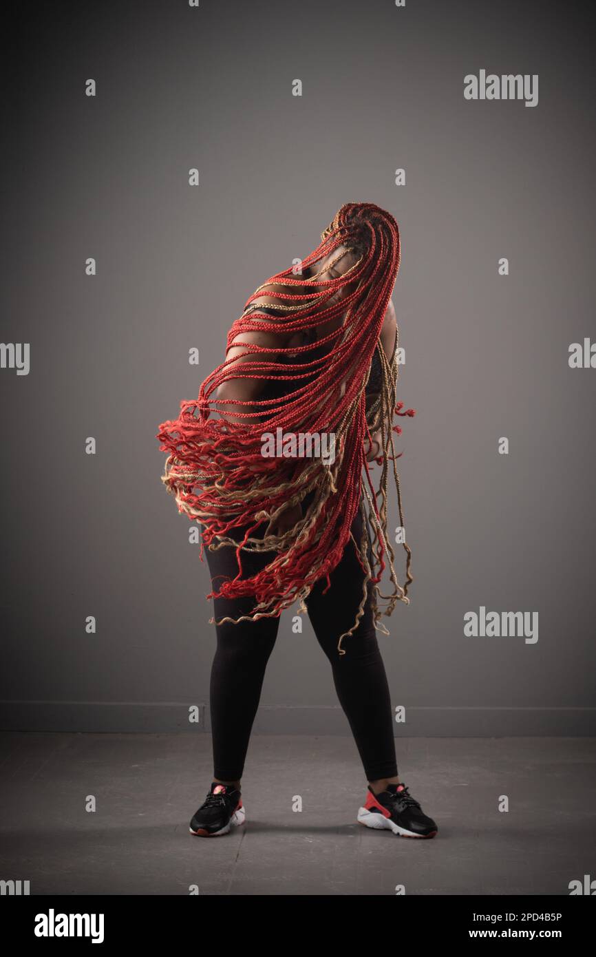An African American female in a black outfit and red braids doing hip ...