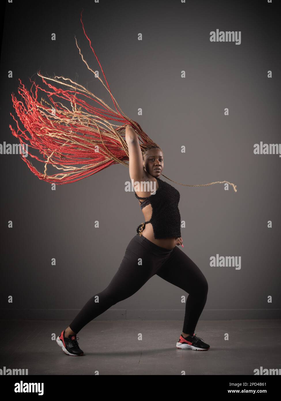 An African American female in a black outfit and red braids doing hip ...