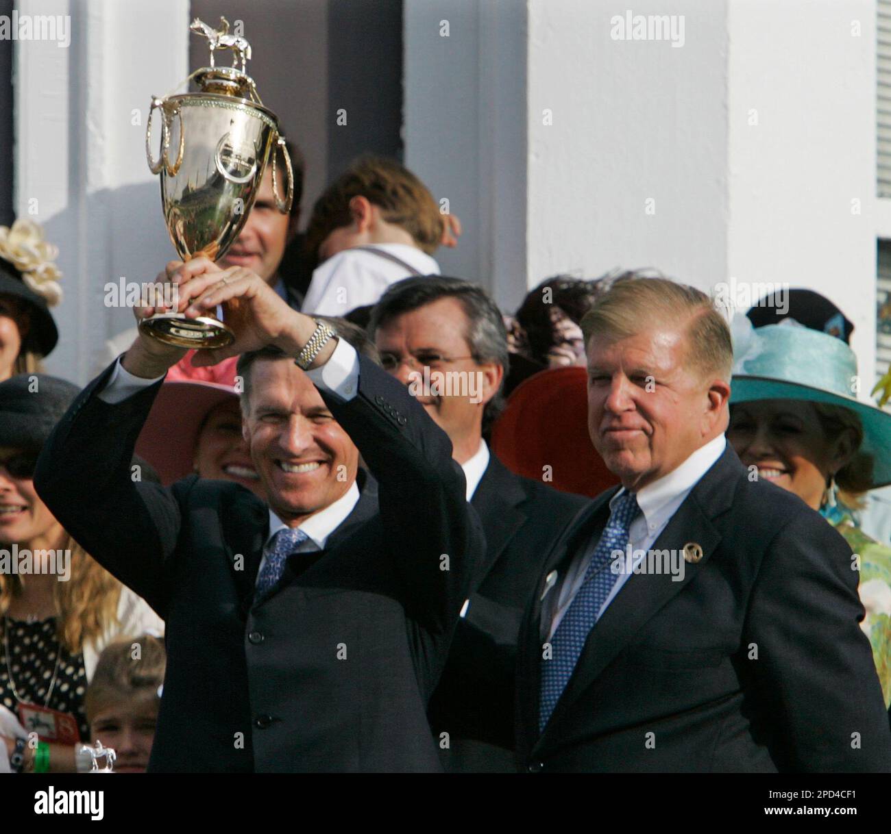 Trainer Michael Matz holds up the winner's trophy with Barbaro's owner ...