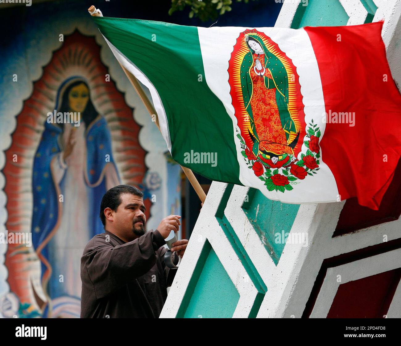 David Rico hangs a Mexican flag before a Cinco de Mayo immigrants ...