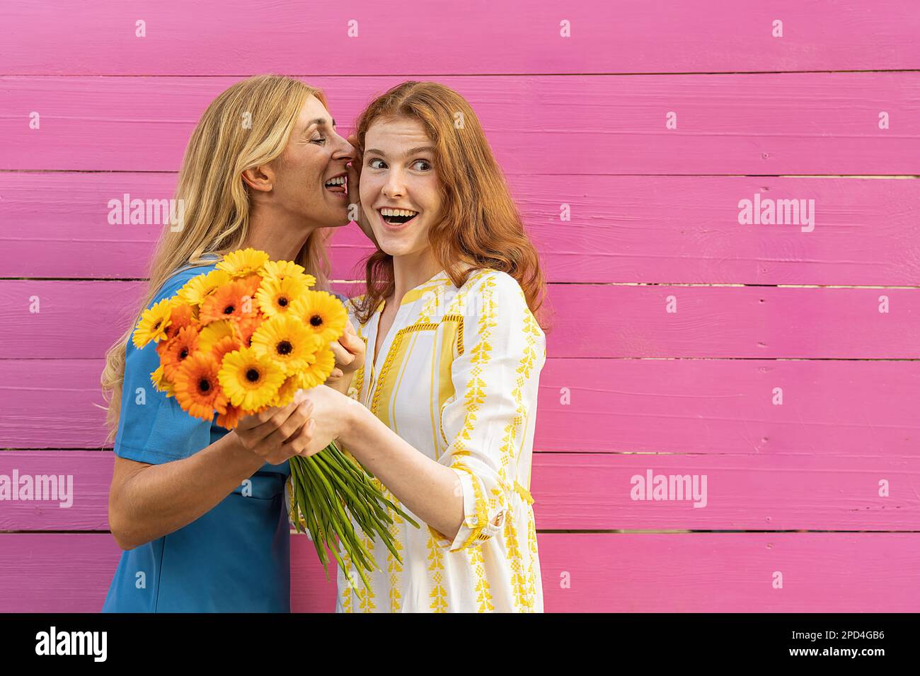 girlfriend whispers a secret in her friend's ear and holding a bunch of ...