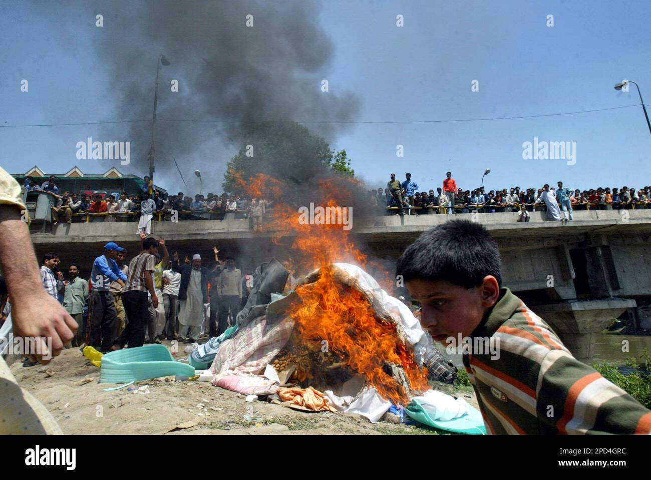 Kashmiri youths shout slogans as the belongings of a woman, suspected ...
