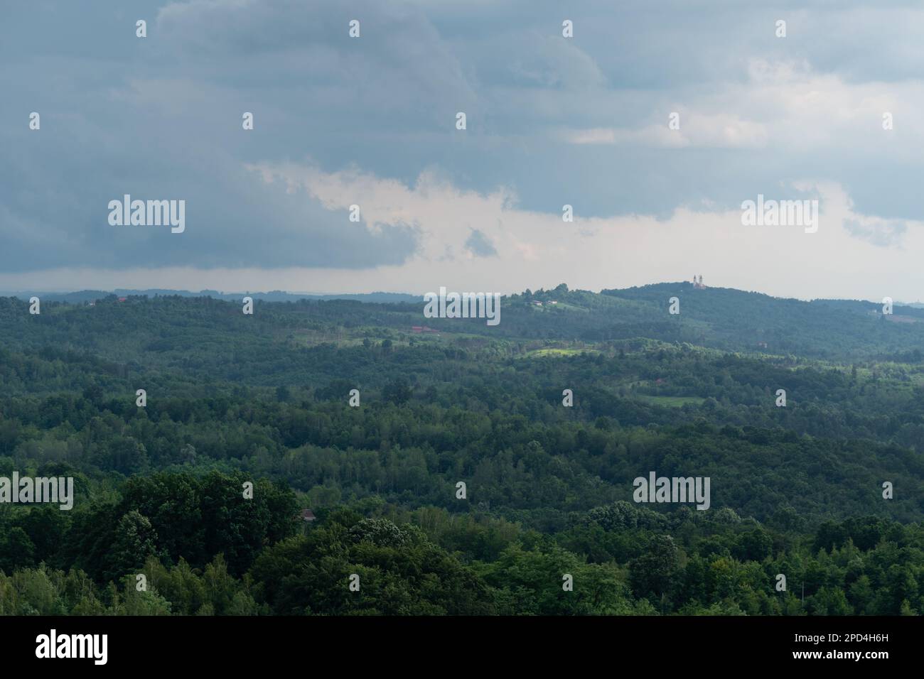 Dark clouds over hilly countryside with sun spots after rain, lush ...