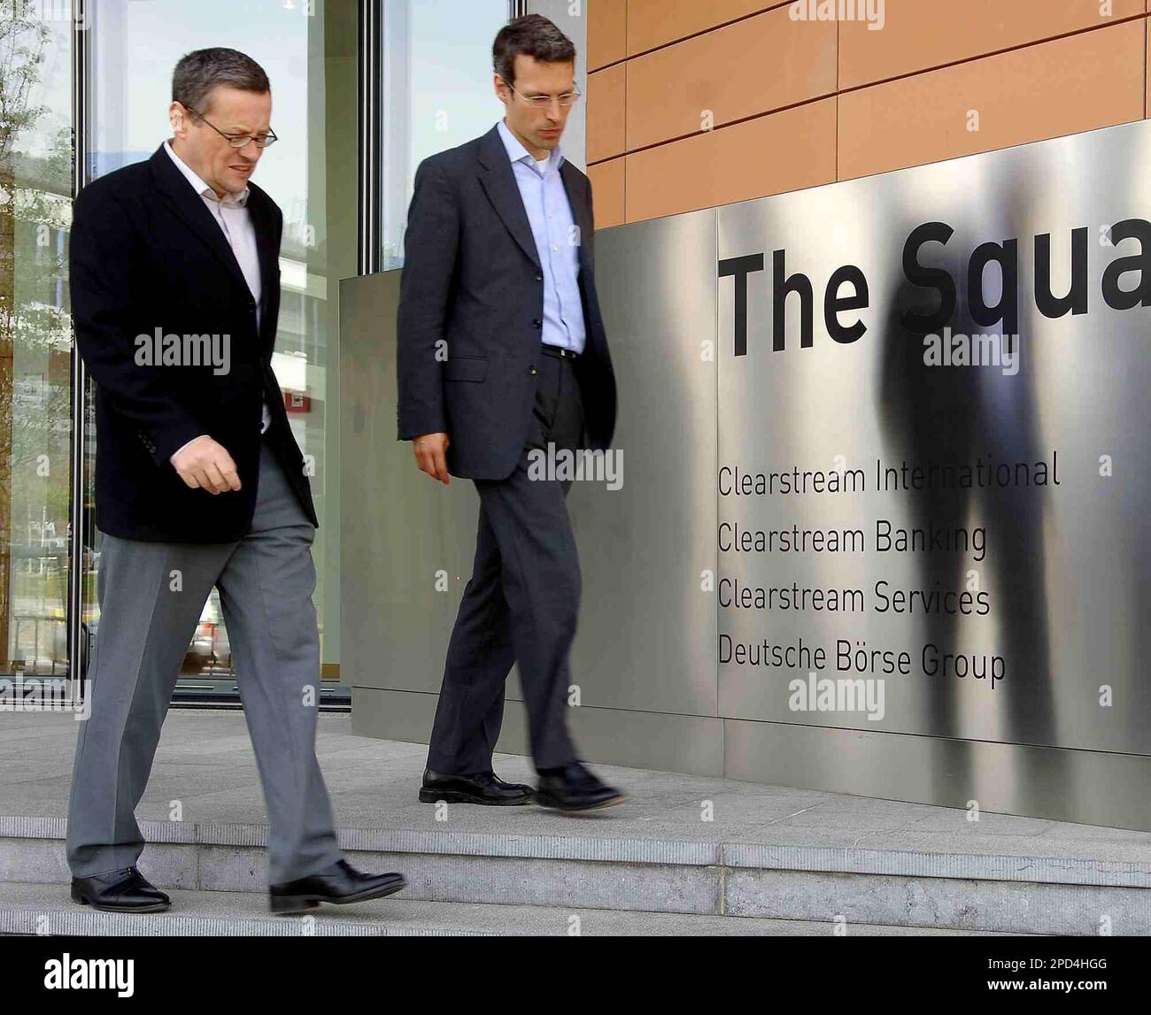 Businessmen walk past the entrance of the Clearstream Bank headquarters ...