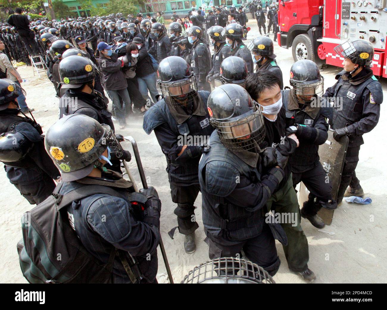 South Korean riot police carry away arrested protesters in Pyeongtaek ...