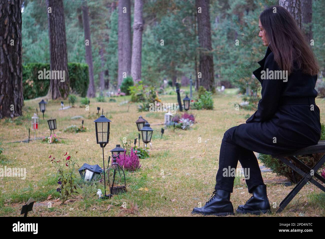 Side view of woman sitting on chair in a cemetery Stock Photo - Alamy