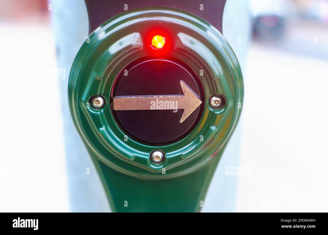 Close-up of a green pedestrian signal button at a crosswalk with red ...