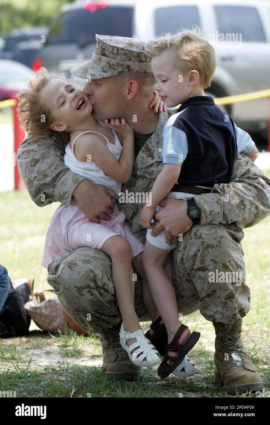 Marine Lt. Col. William Lucas holds his twin children Kayla, left, and ...