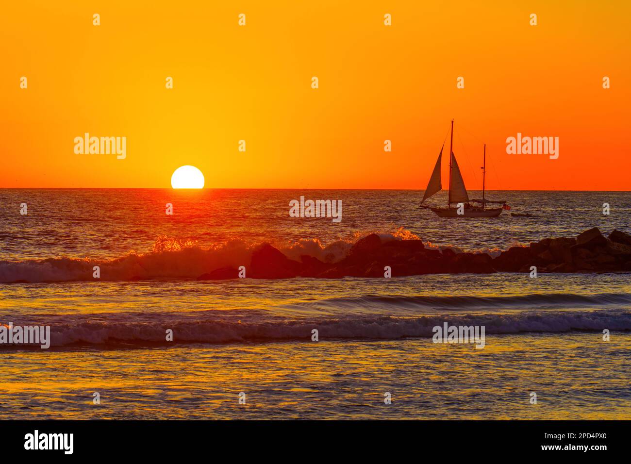 Fiery sunset landscape with a sailboat riding the waves of the ocean. Beauty of the ocean, the ...