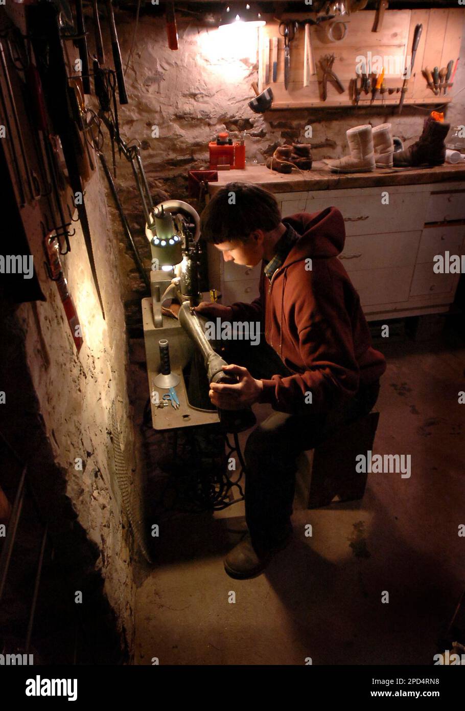 Evan Mercer, 17, sews a boot in the work area of his home in Sterling ...