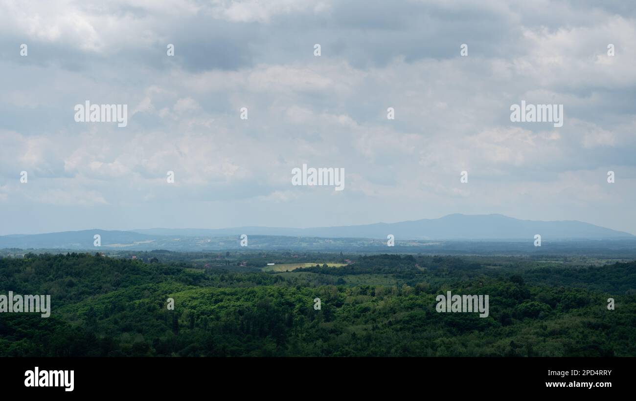 Countryside hilly landscape with villages during cloudy day, sun spot ...