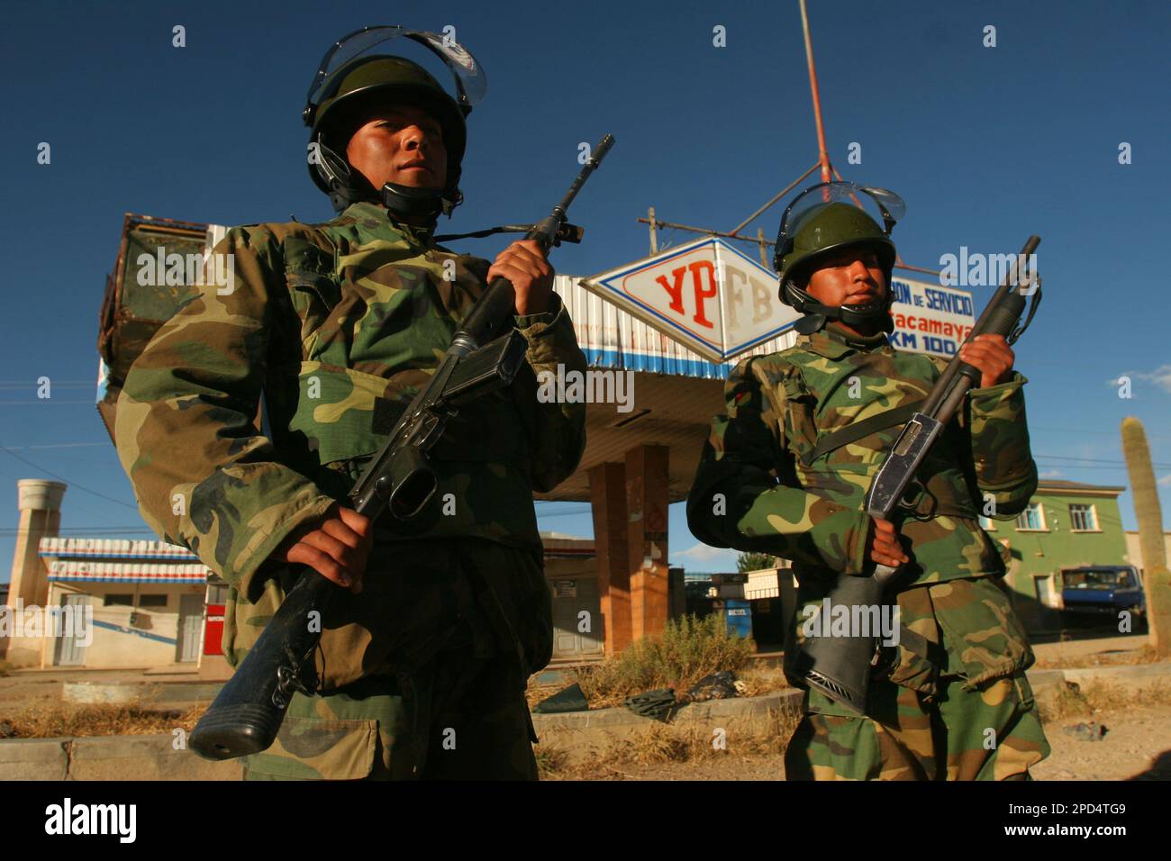 Bolivians military officers stand guard in front of an old gas station ...