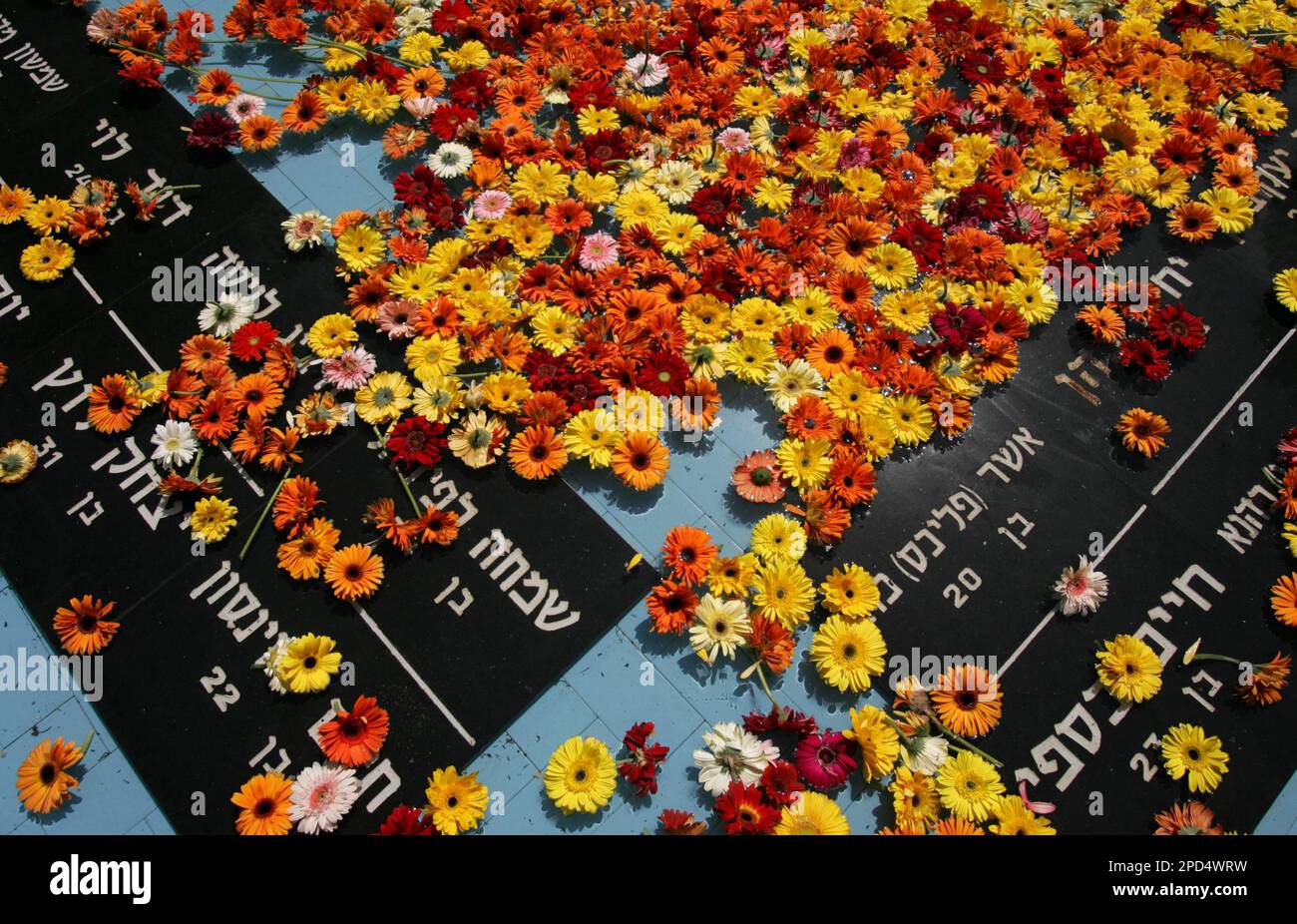 Flowers float on a monument as the names of soldiers are seen written ...