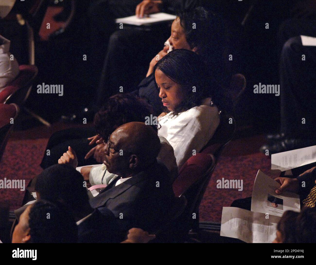 Phiana Wilcox, center, listens to speakers talk about her father ...