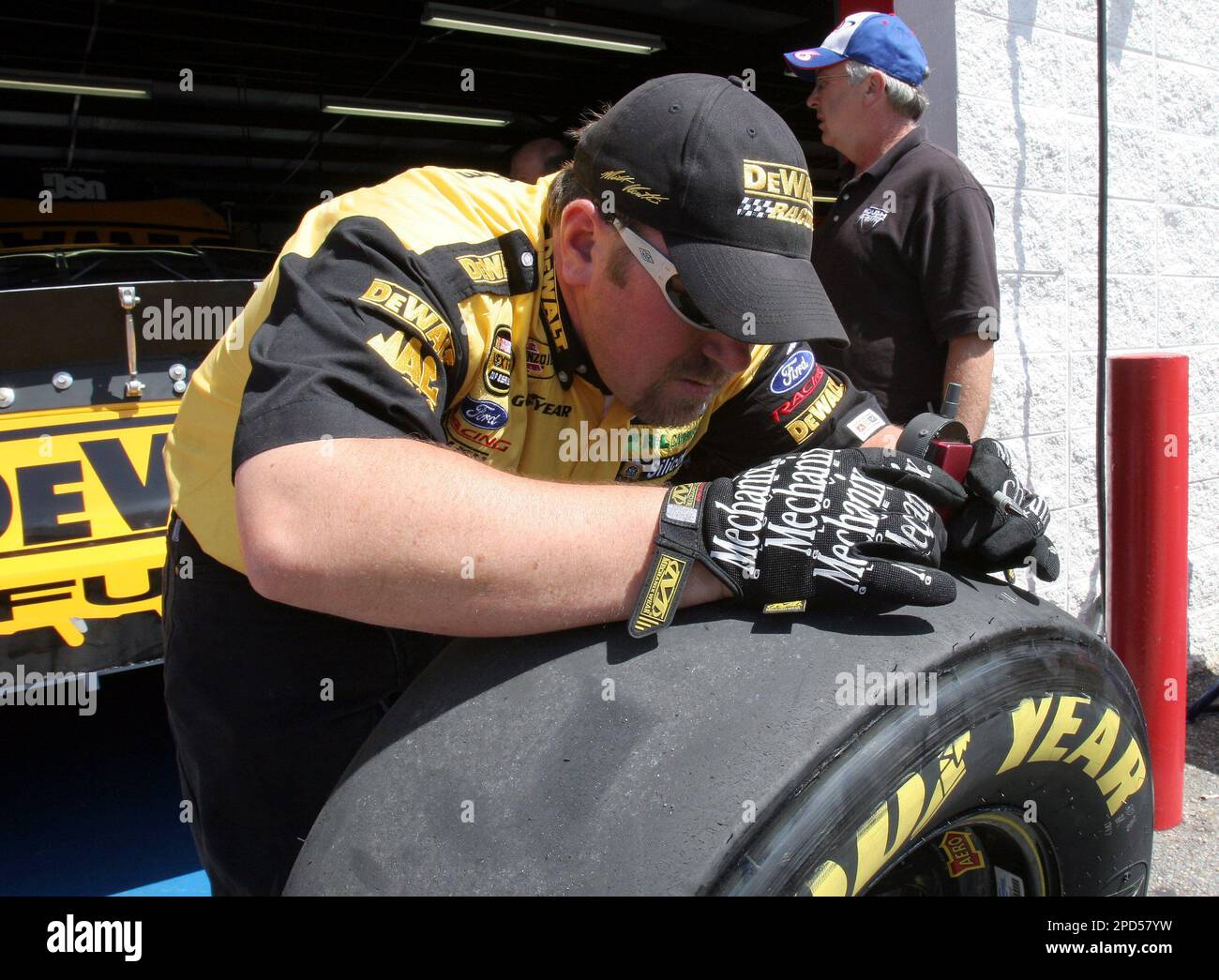 Ken Gober, a tire man for Matt Kenseth's team, performs a tire check ...