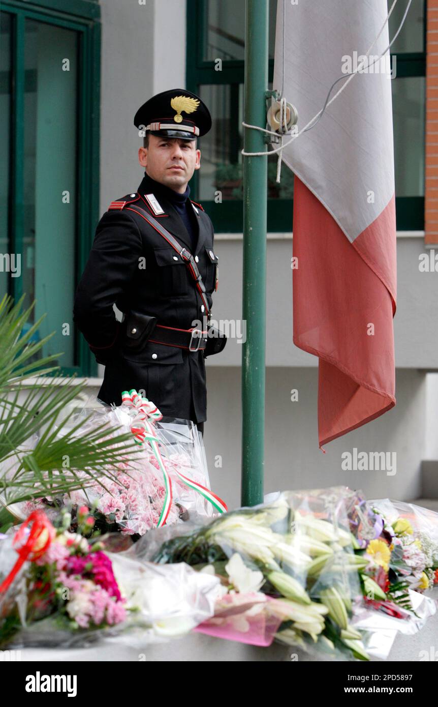An Italian Carabinieri paramilitary officer stands by an Italian flag ...