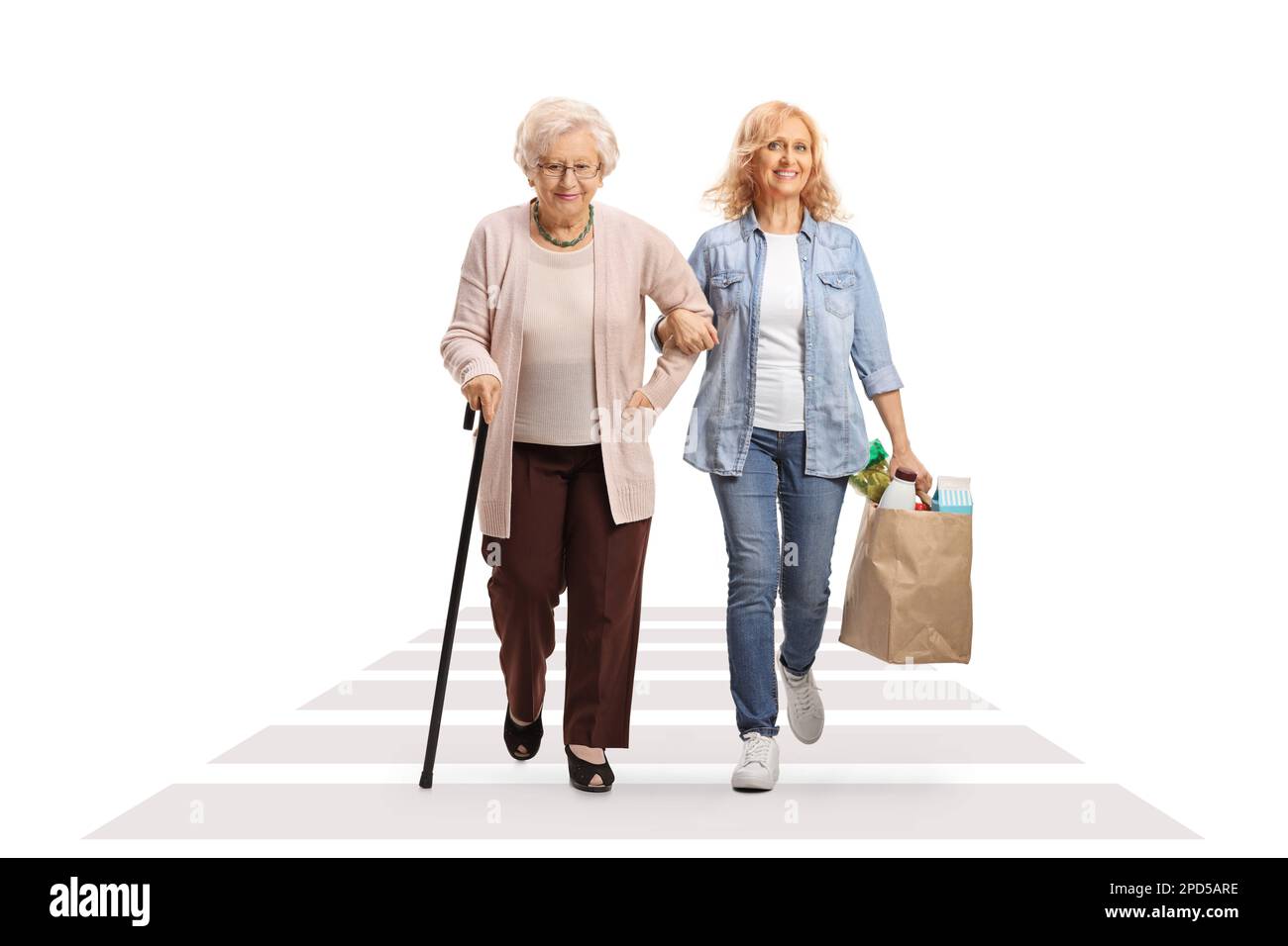 Woman helping an elderly lady with shopping bags on a pedestrian ...