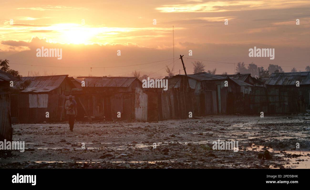A man walks by shacks in the slum of Cite-Soleil in Port-au-Prince ...