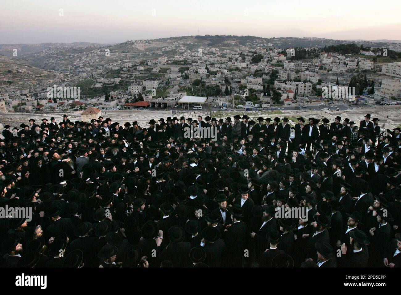 Ultra-Orthodox Jewish men gather around the body, not seen, of Rabbi ...