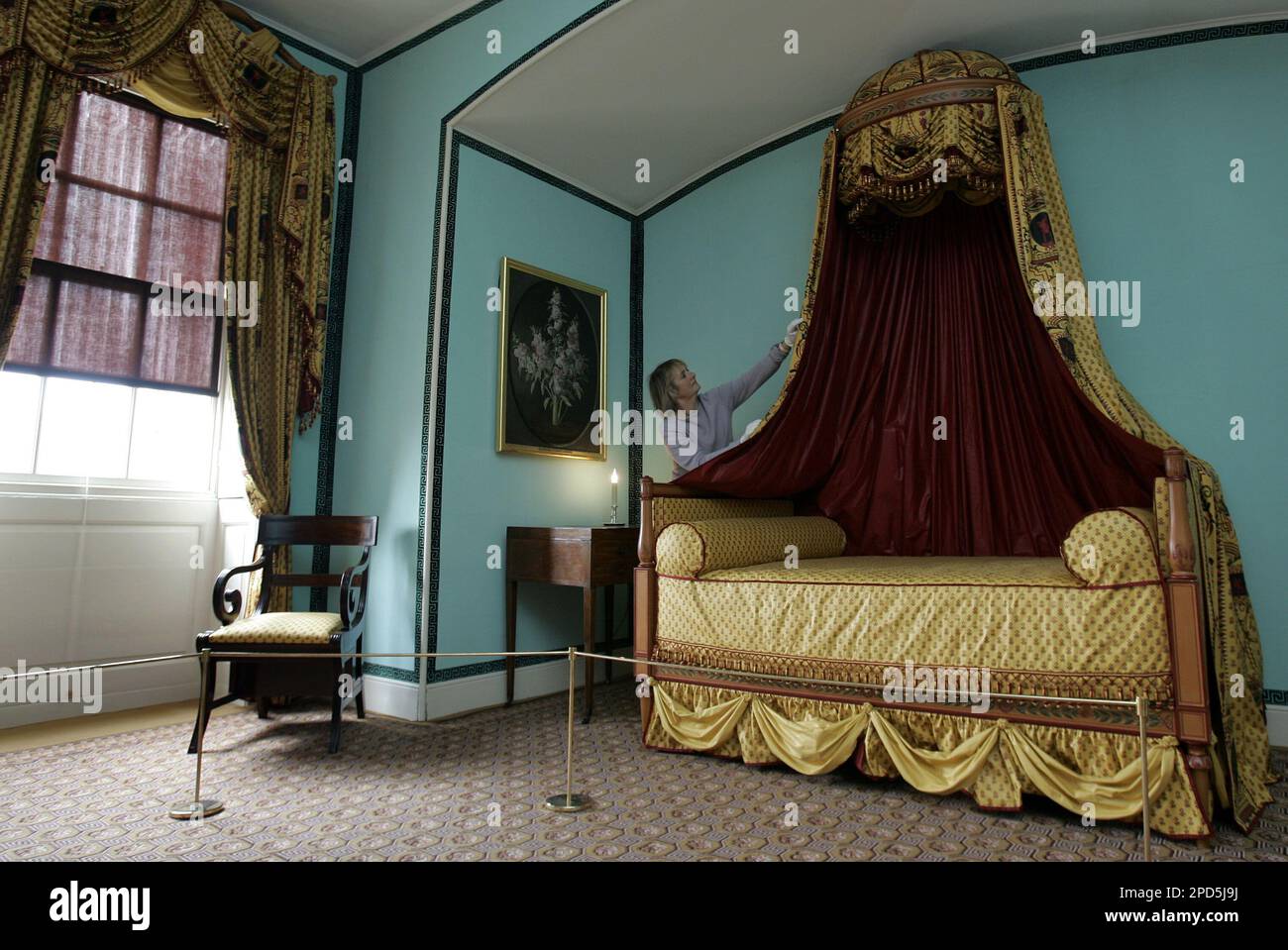 A curator adjusts the drapes in Princess Elizabeth's bedchamber in Kew ...