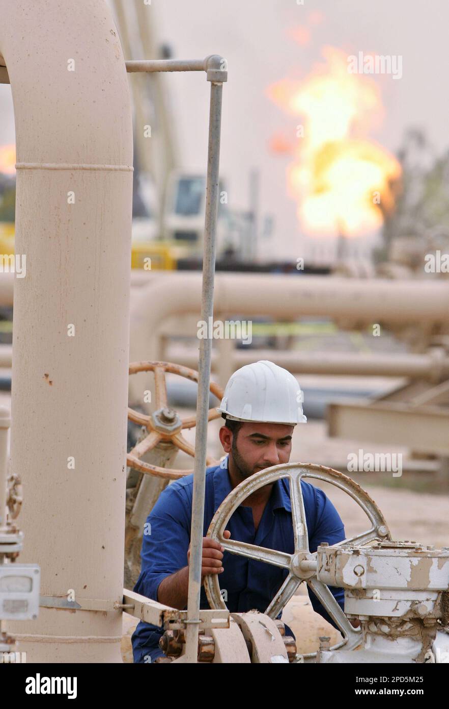 An Iraqi man turns a valve at a new plant for gas production near Basra ...