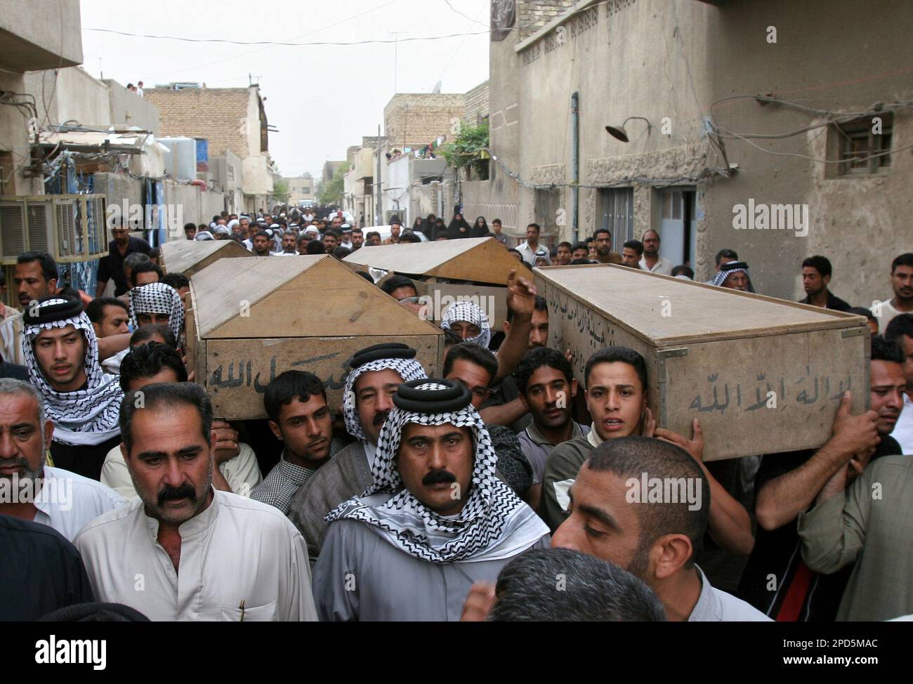 Iraqi men carry the coffins of three brothers and a cousin who were ...