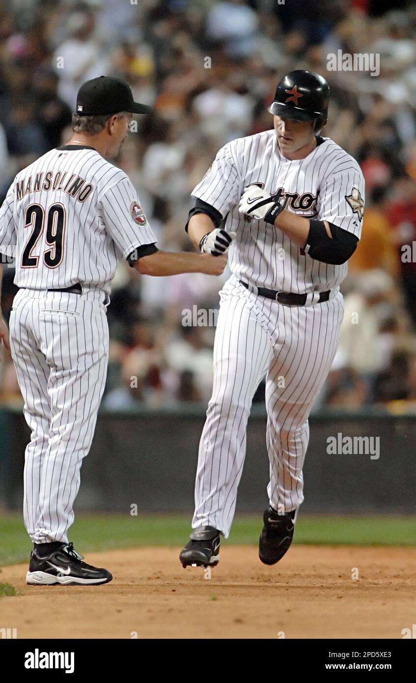 Houston Astros' Jason Lane, right, is greeted by third base coach Doug ...