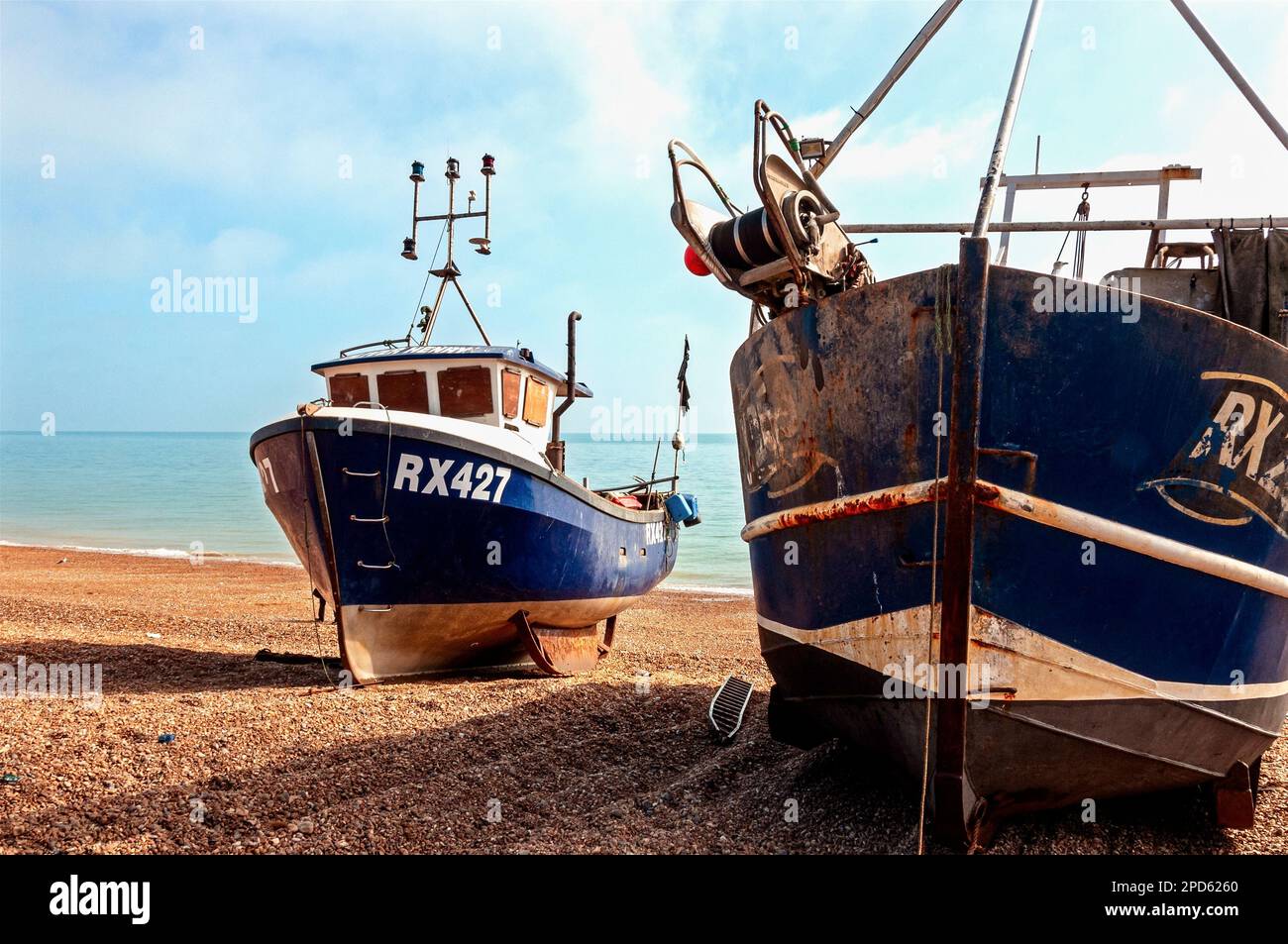 White and blue steel hulled fishing netter boats RX427 RX256 rest on ...