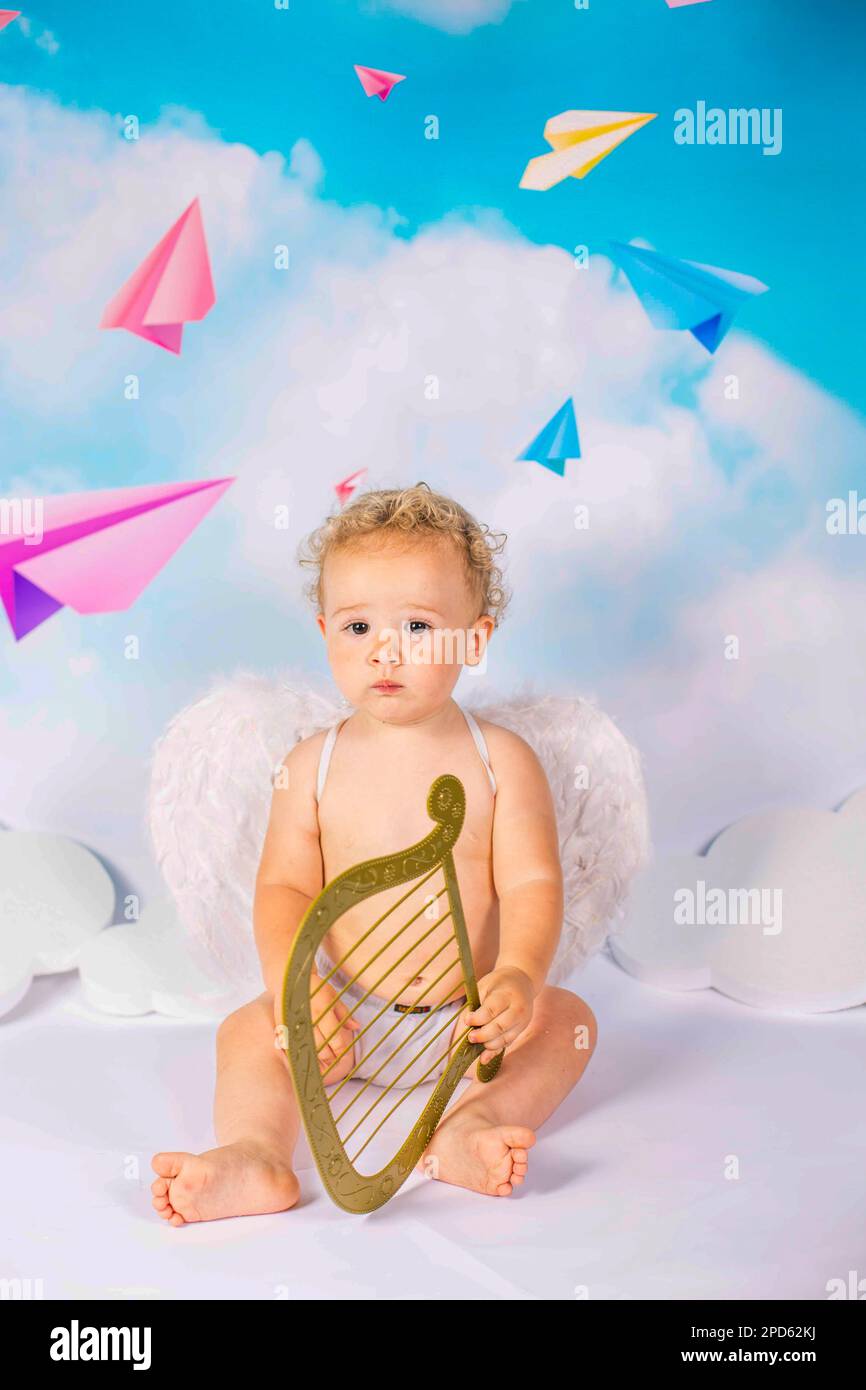 angel child is sitting the clouds looks down Stock Photo - Alamy
