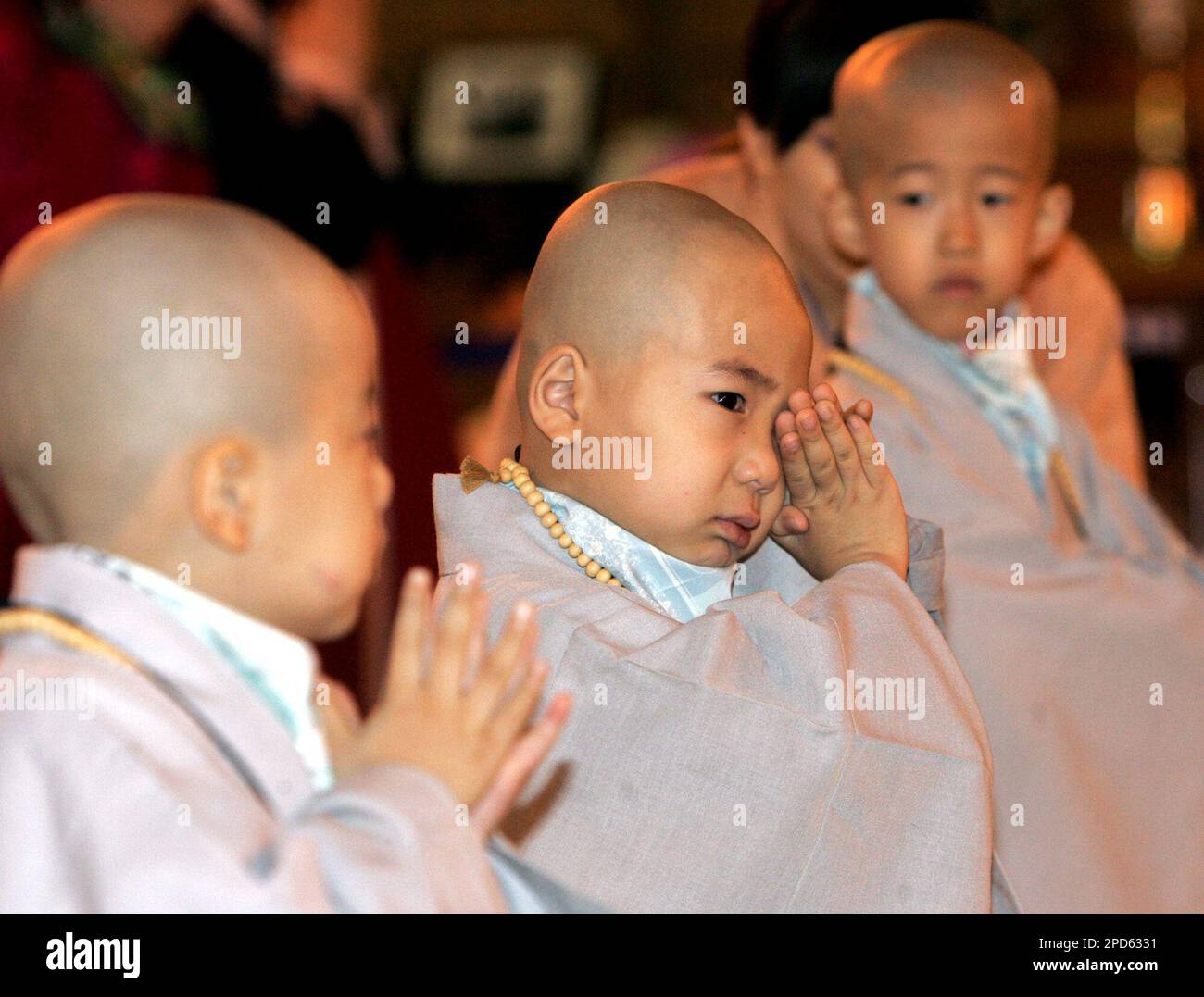 An unidentified South Korean child wipes his tears after his head was ...