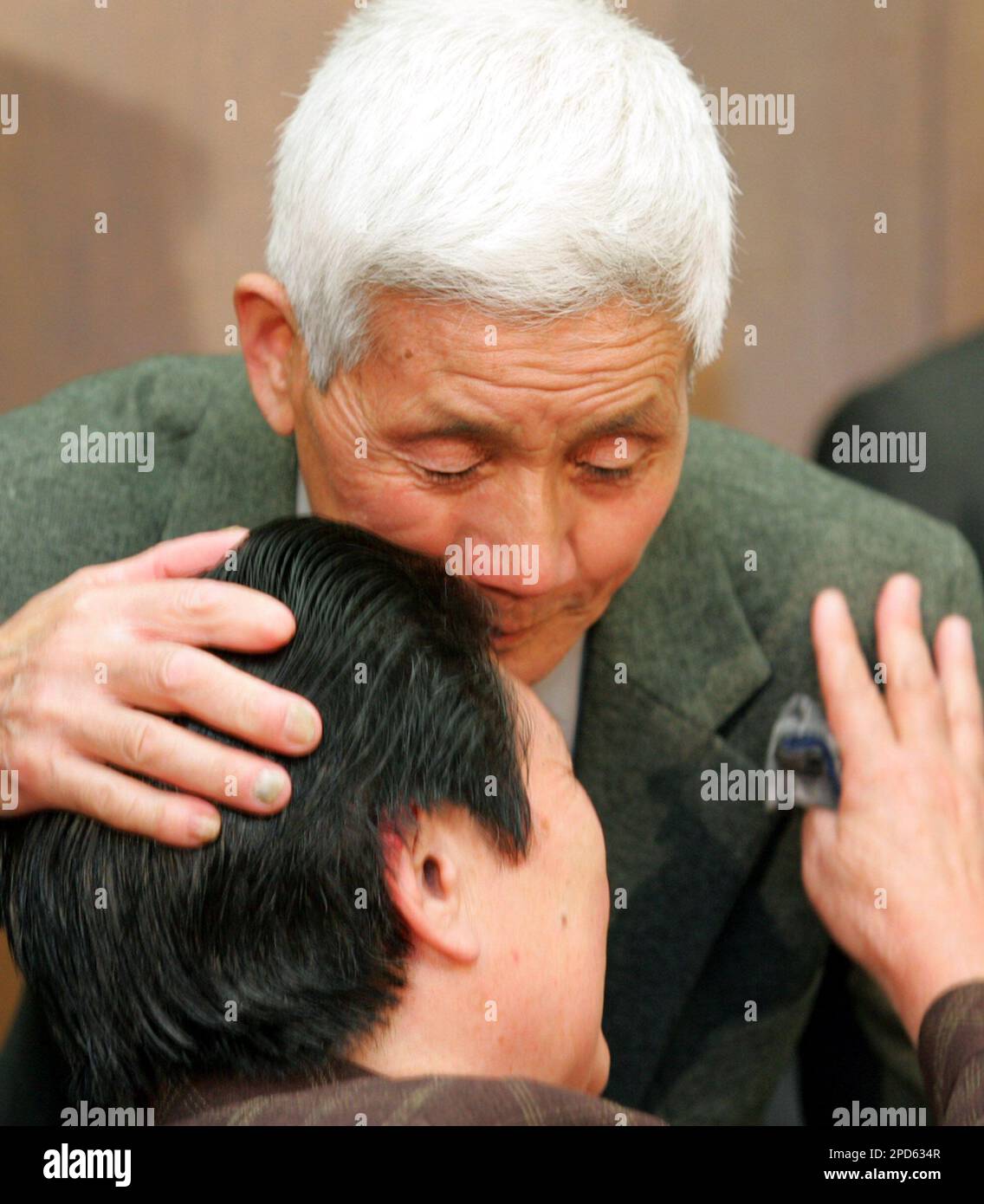 Former Japanese soldier Ishinosuke Uwano, top, hugs his younger sister ...