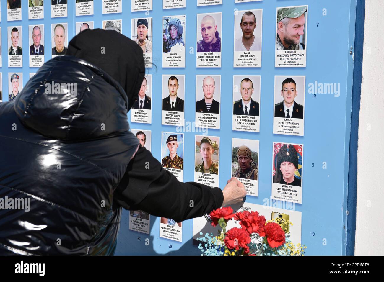 Kyiv, Ukraine. 14th Mar, 2023. A woman puts flowers at the wall of ...