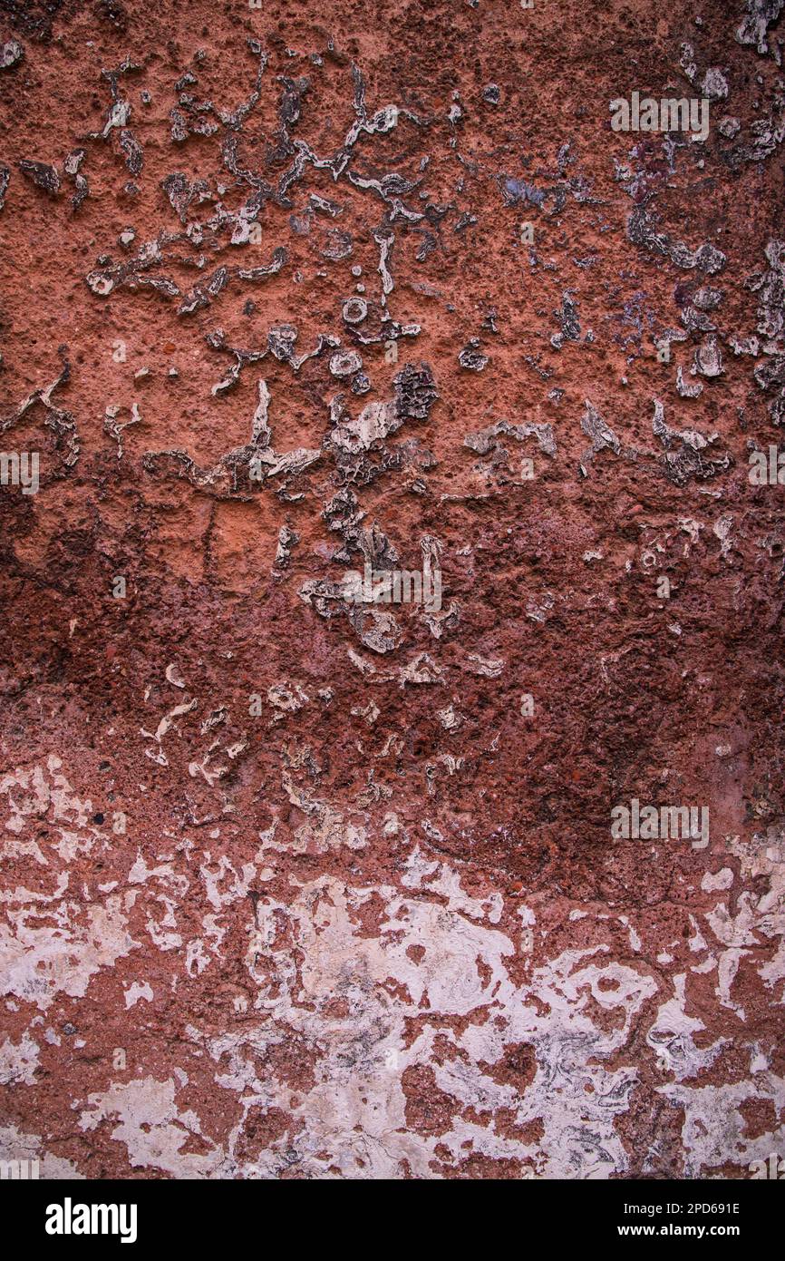 The texture of an old rustic wall is covered with red stucco. Abstract ...