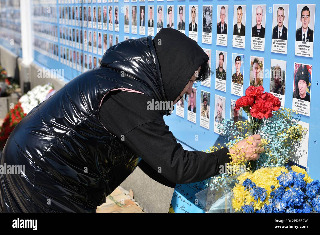 Kyiv, Ukraine. 14th Mar, 2023. A woman puts flowers at the wall of ...