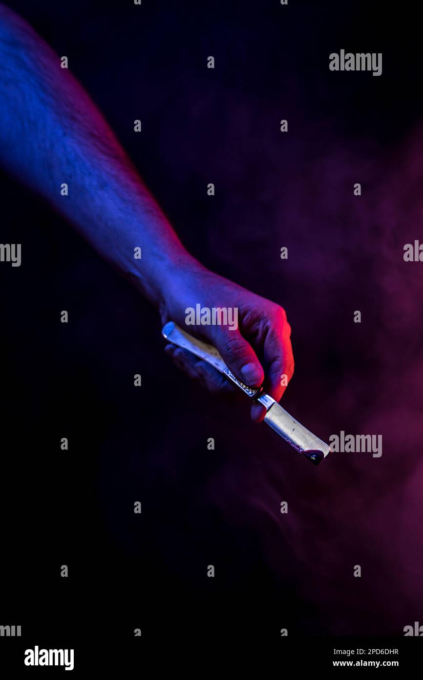 Bloody straight edge razor in the hand of a killer Stock Photo - Alamy