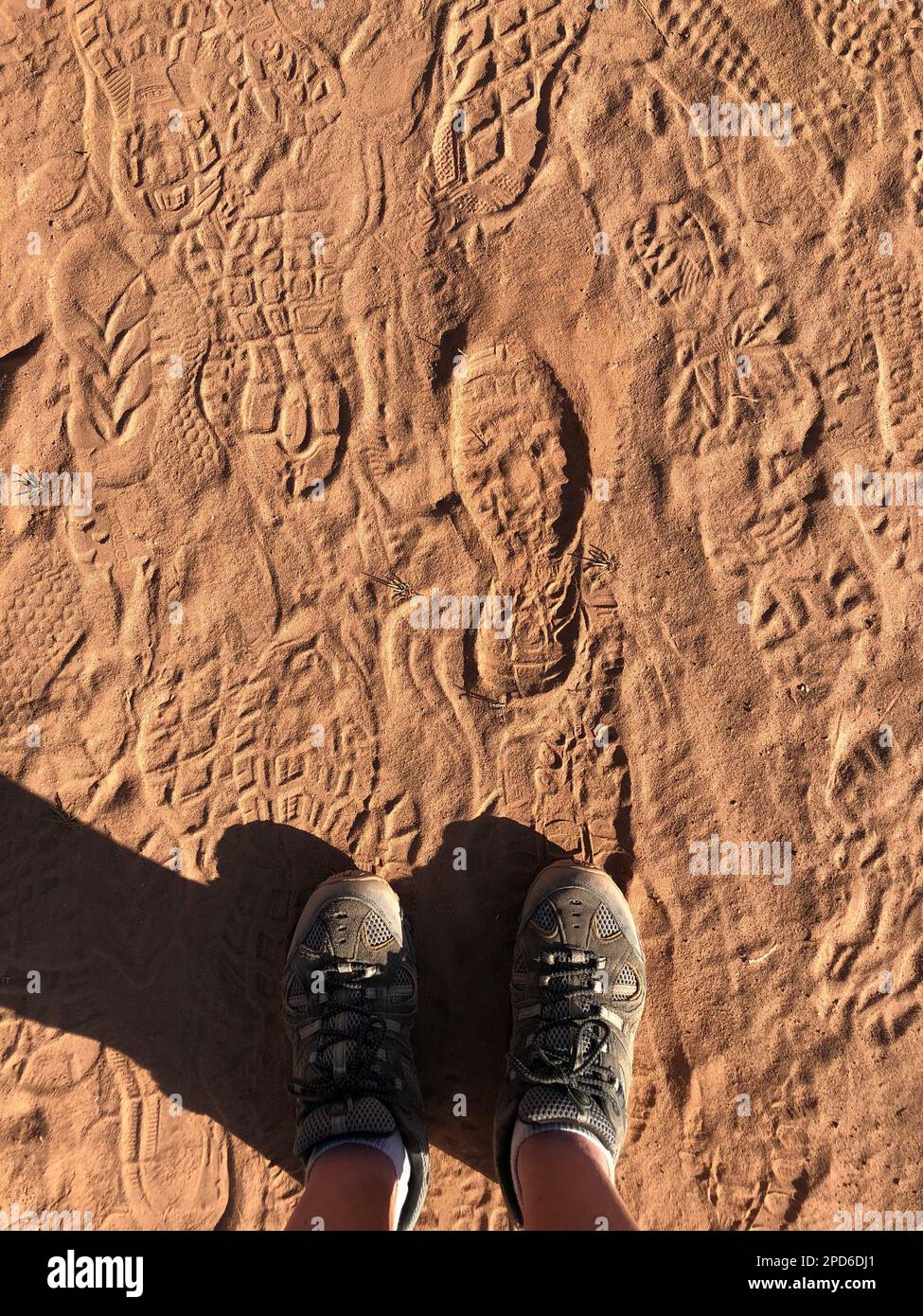 Shot looking down on feet standing in red dirt with footprints Stock ...