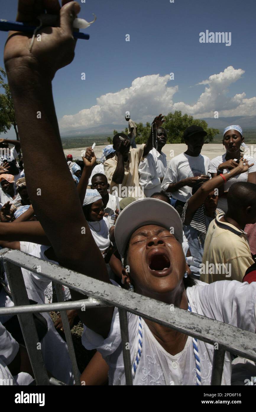 A Haitian woman prays during a pilgrimage at the mount of Calvaire ...