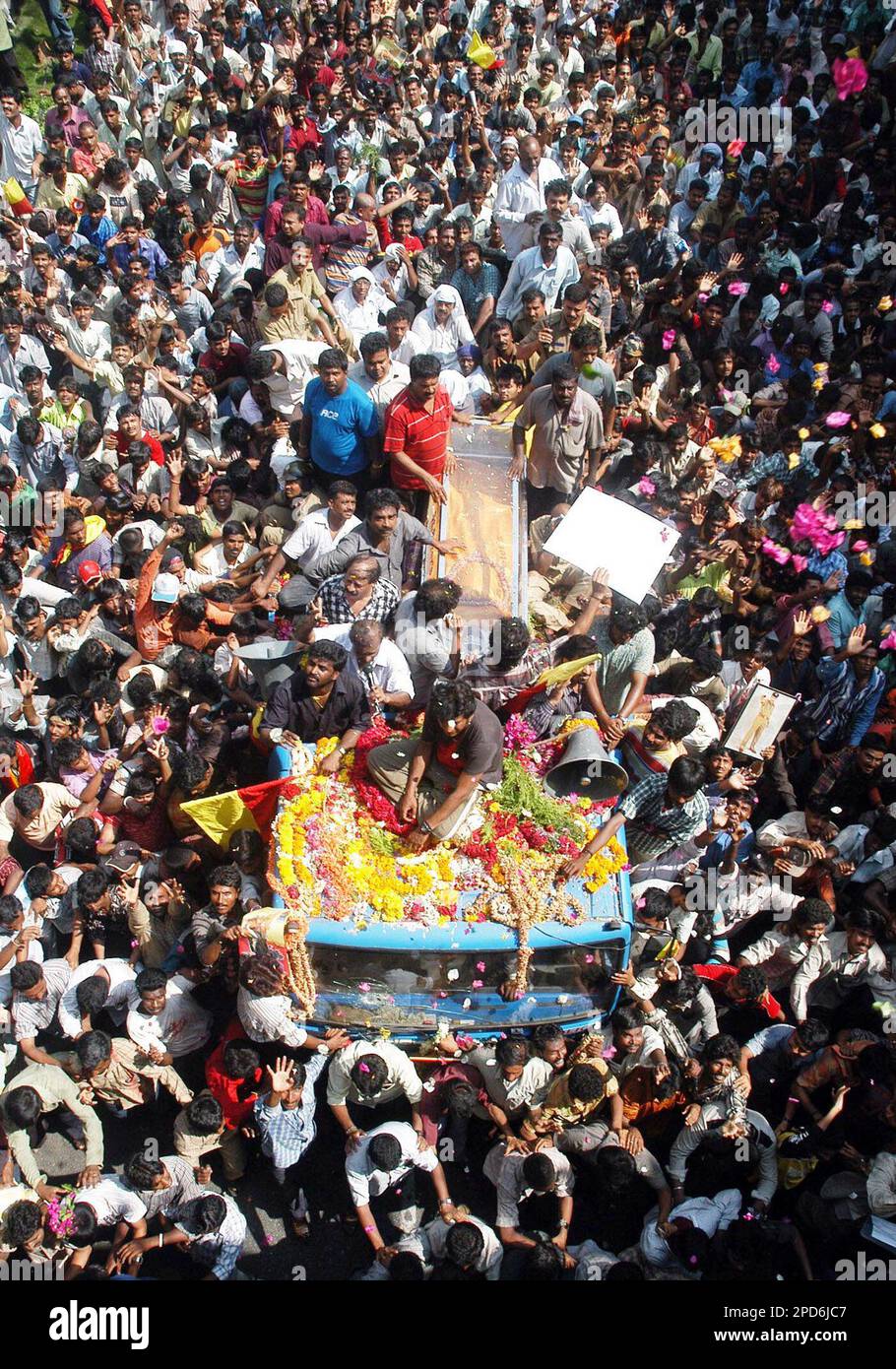 Funeral procession of actor Raj Kumar passes through a street in ...