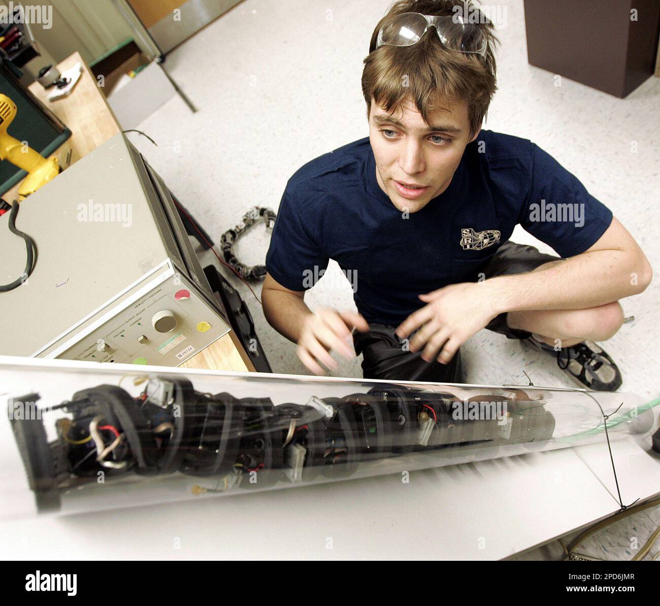 Chris Borer demonstrates a snake robot climbing up the inside of a ...